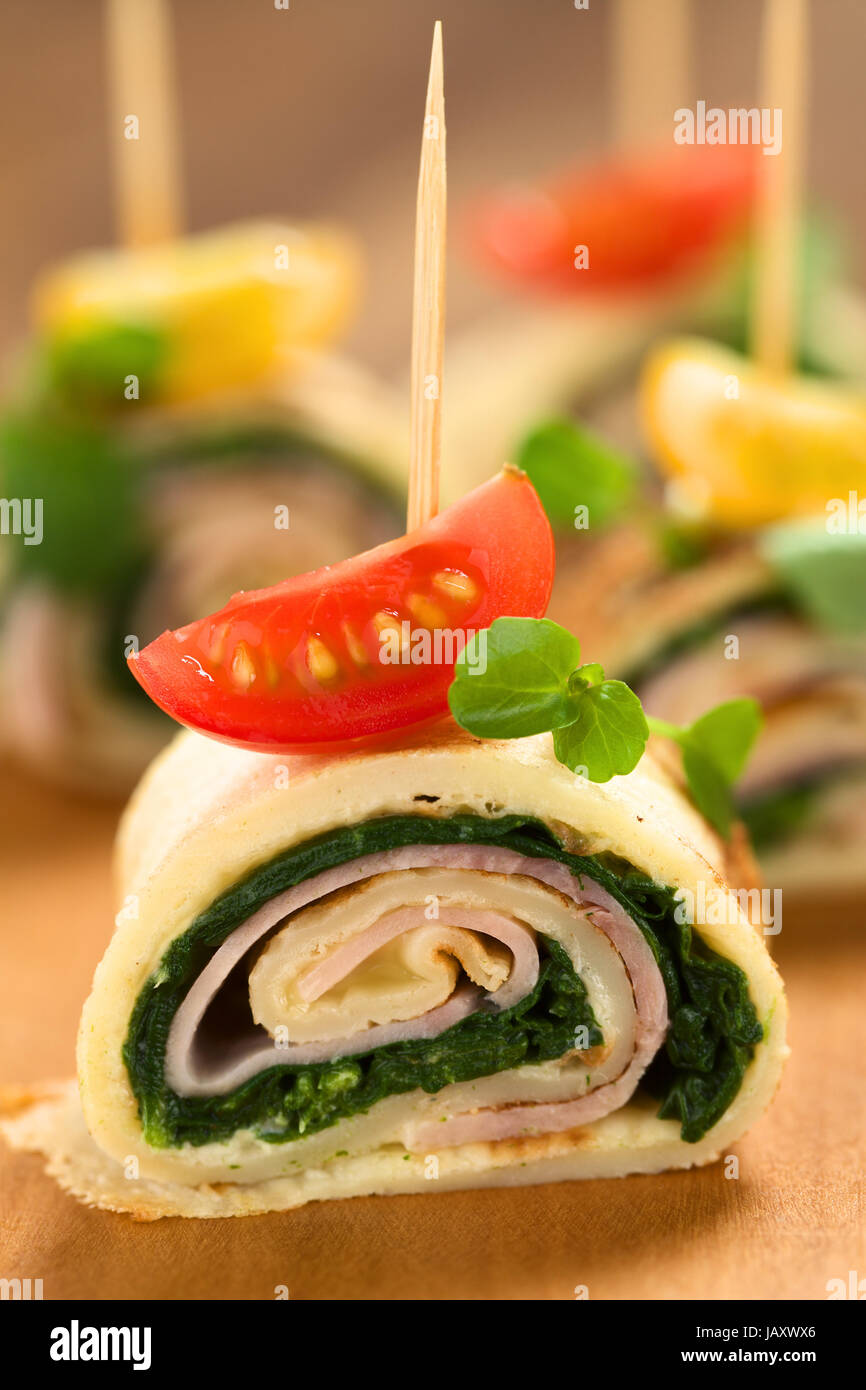 Crepe rolls as finger food filled with spinach and ham garnished with ...