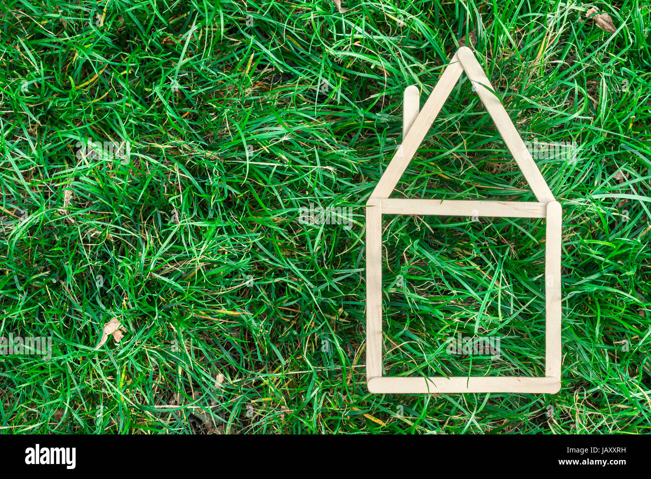 Model house made of wooden sticks on green grass Stock Photo - Alamy