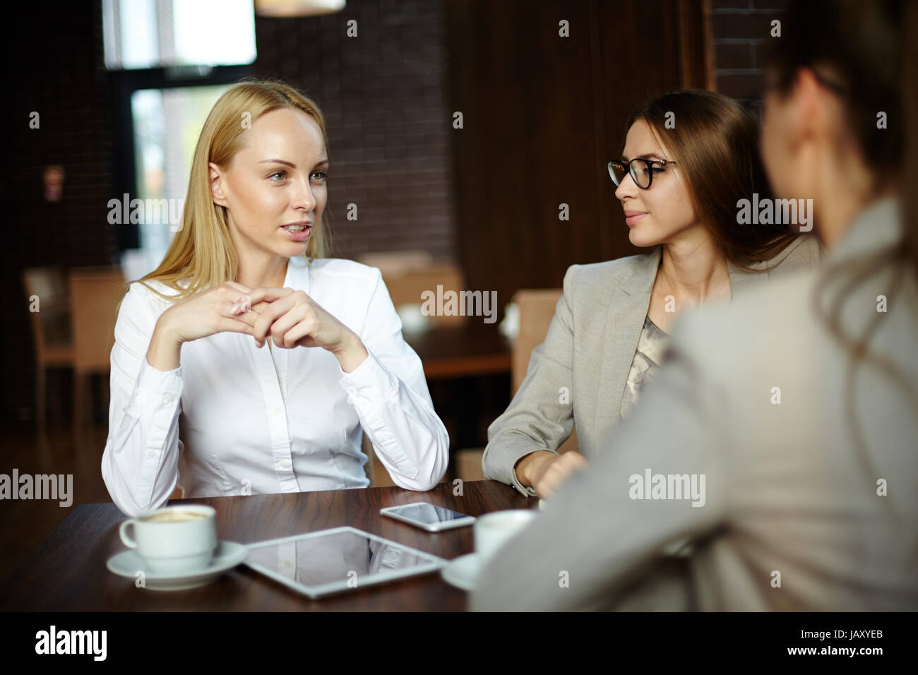 Sharing Ideas with Pretty Colleagues Stock Photo - Alamy