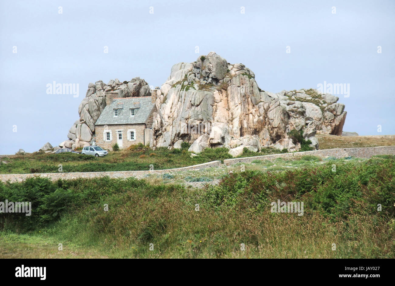 traditional breton house between some rocks at the Pink Granite Coast ...