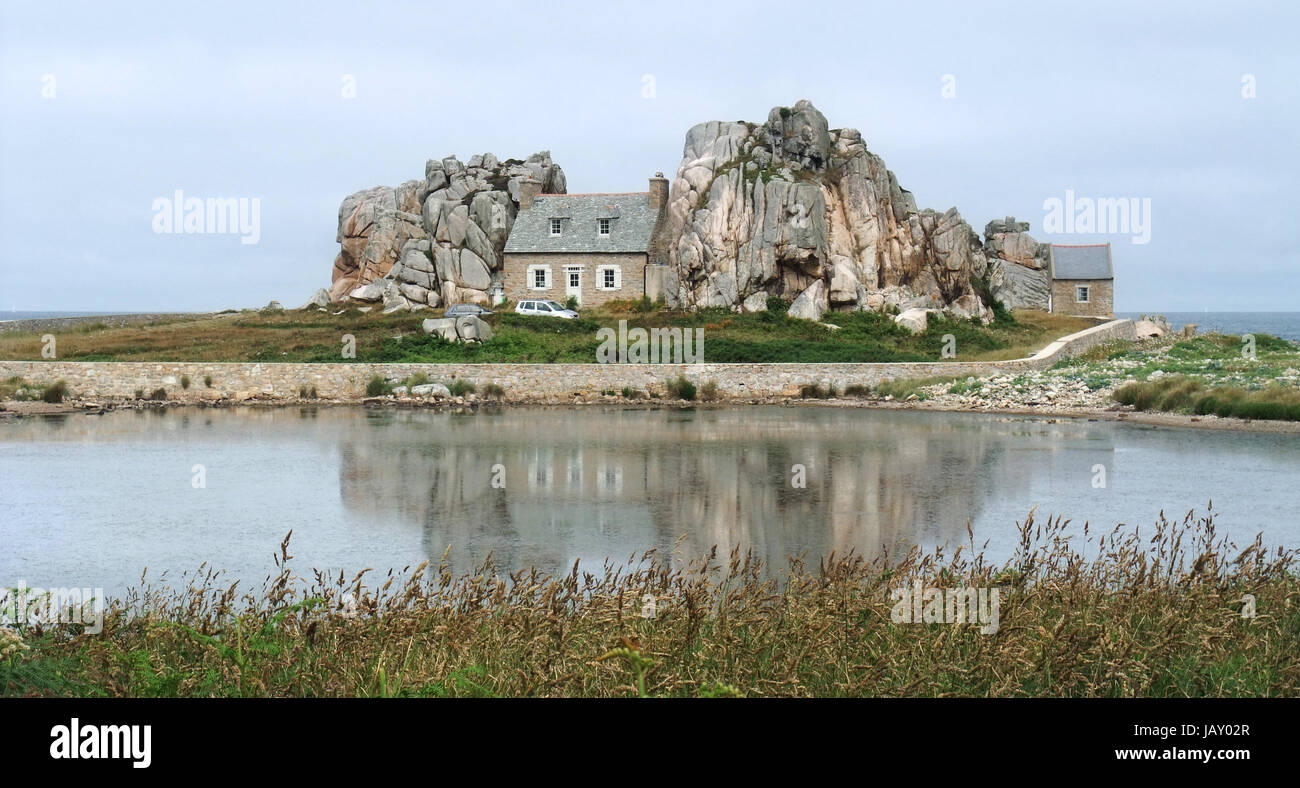 traditional breton house between some rocks at the Pink Granite Coast ...