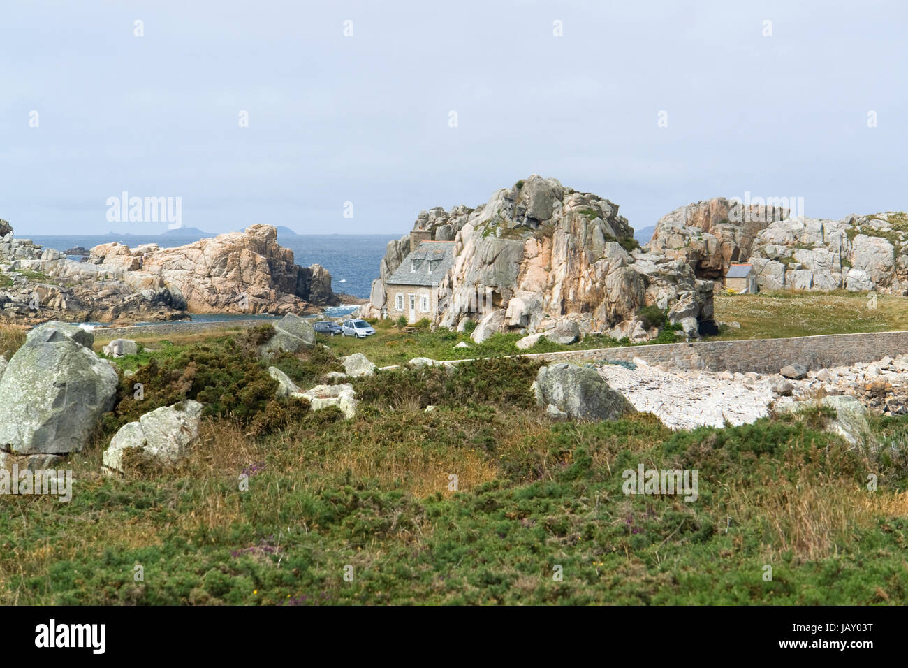 traditional breton house between some rocks at the Pink Granite Coast ...