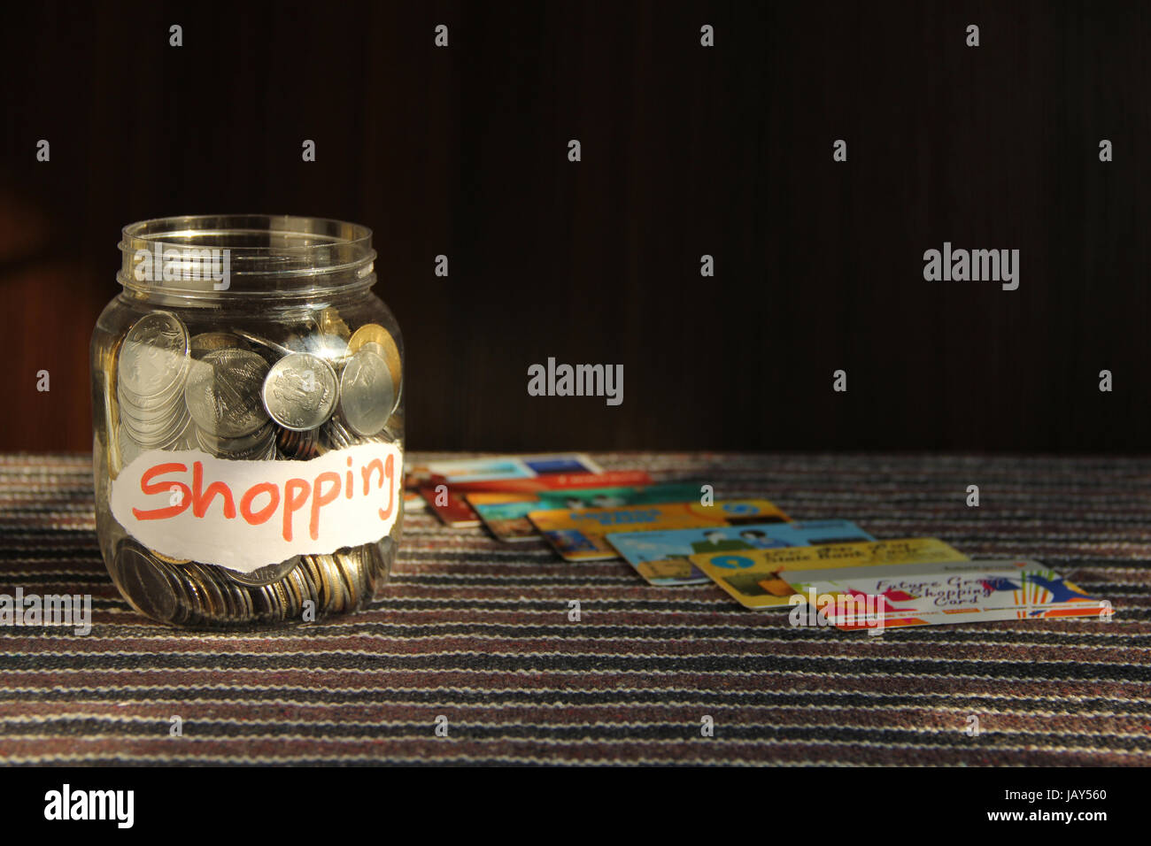 Coins in money jar with shopping label and credit cards, finance ...