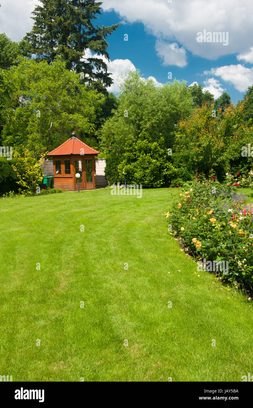 Beautiful garden with blooming roses and a small gazebo Stock Photo - Alamy