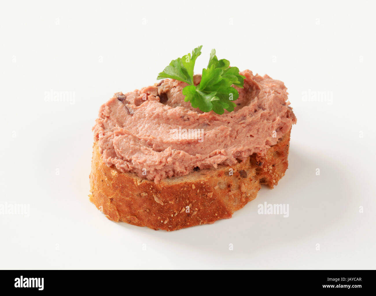 Slice of whole grain bread roll spread with pate Stock Photo - Alamy