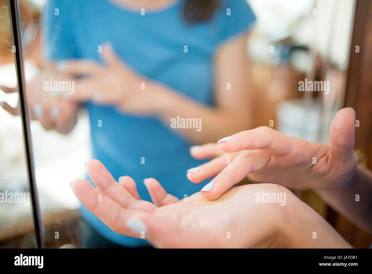 A woman doing makeup using foundation cream Stock Photo - Alamy