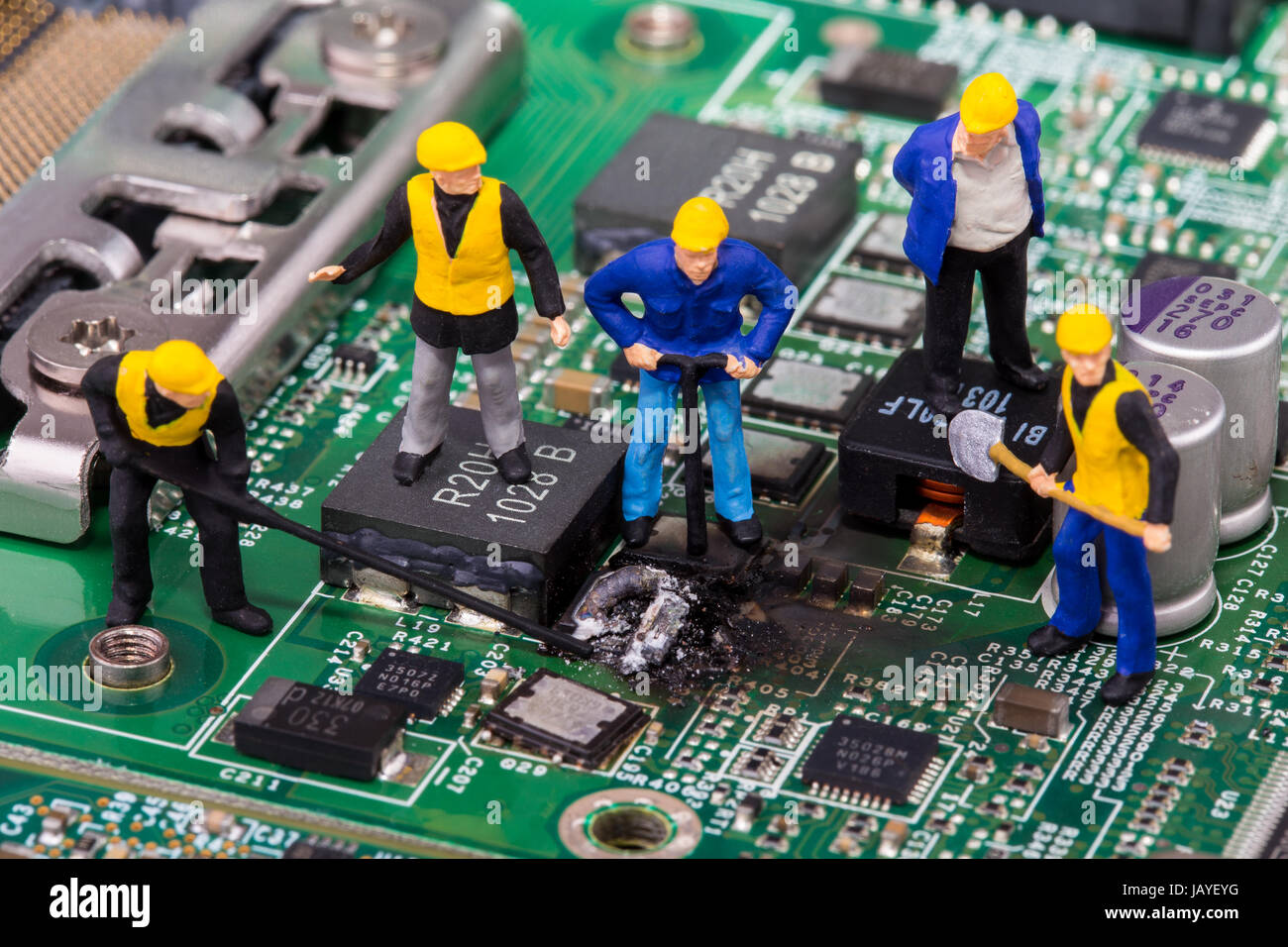 miniature workers on a computer mainboard - studio shot Stock Photo - Alamy