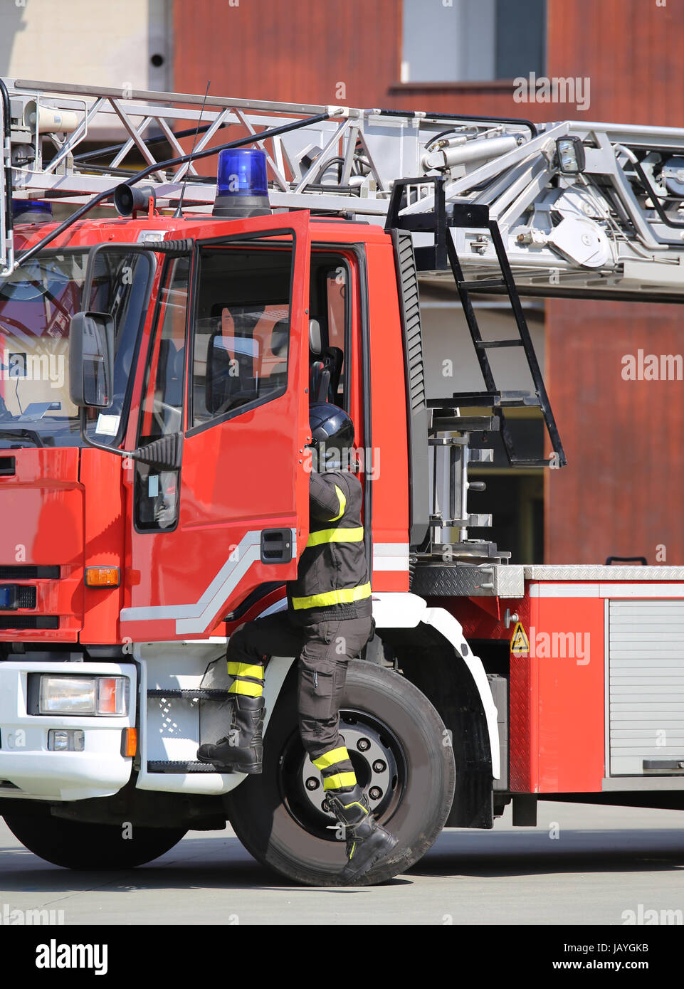 Firefighter drops from the fire truck during firefighting Stock Photo ...