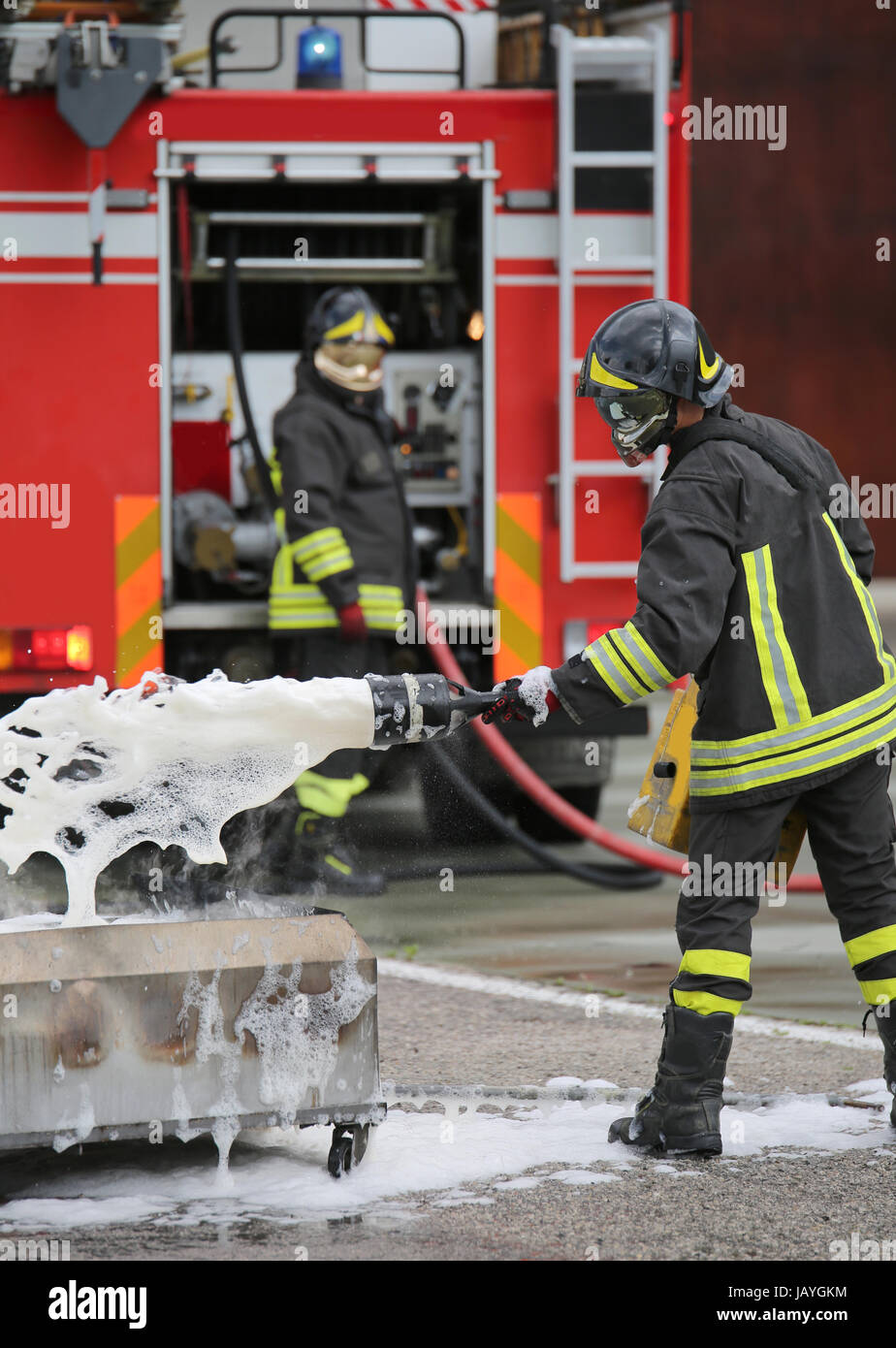 Firefighter training and extinguishing with foam and fire truck on the ...