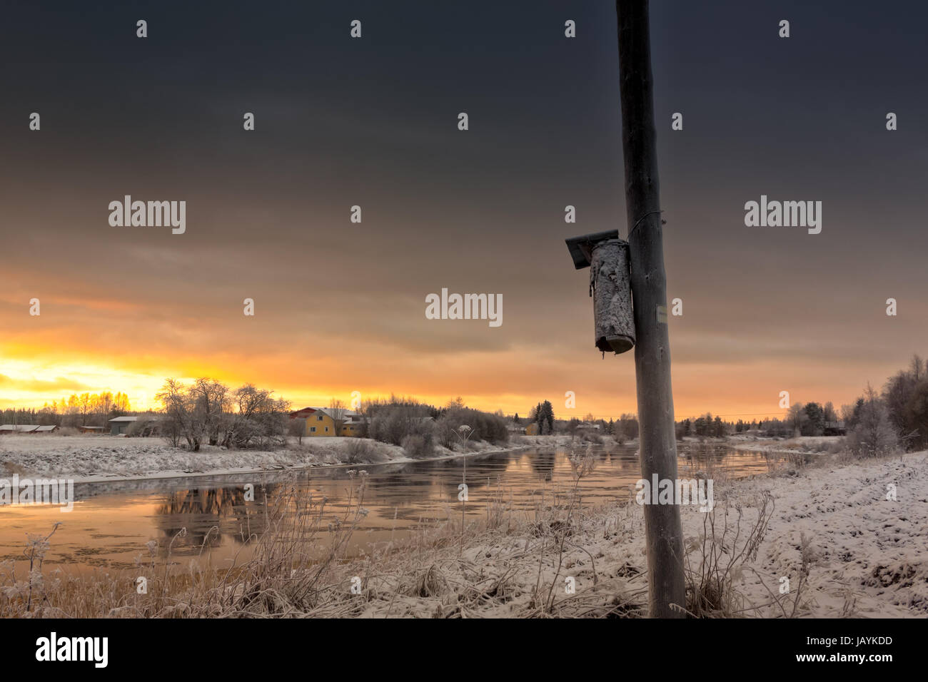 An old birdhouse attached to the telephone pole against the sunrise in ...