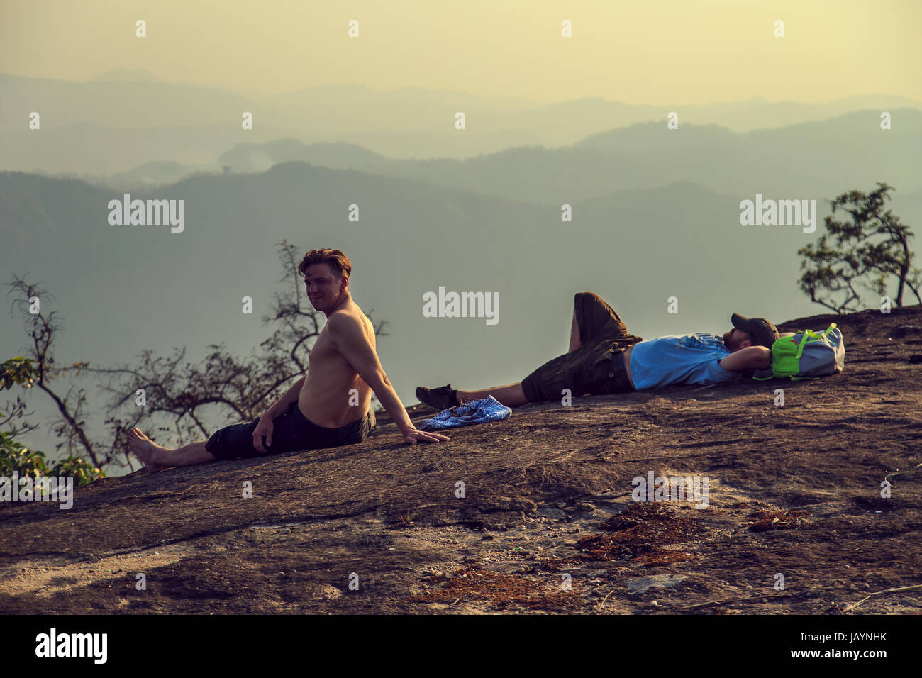 Group of tourists watching the sunset on top of the mountain. Rest ...