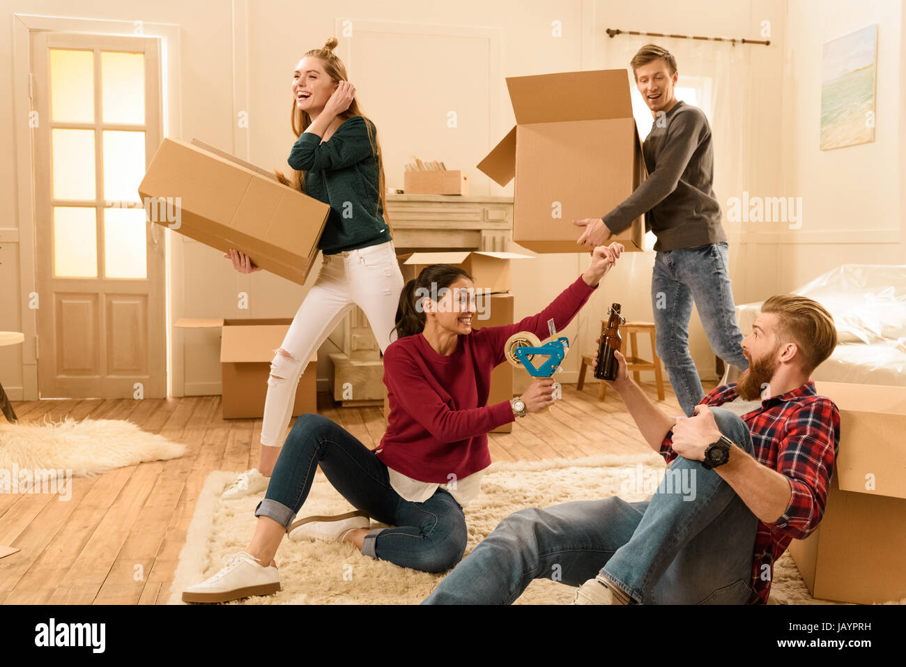 friends having fun in new house while unpacking things Stock Photo - Alamy