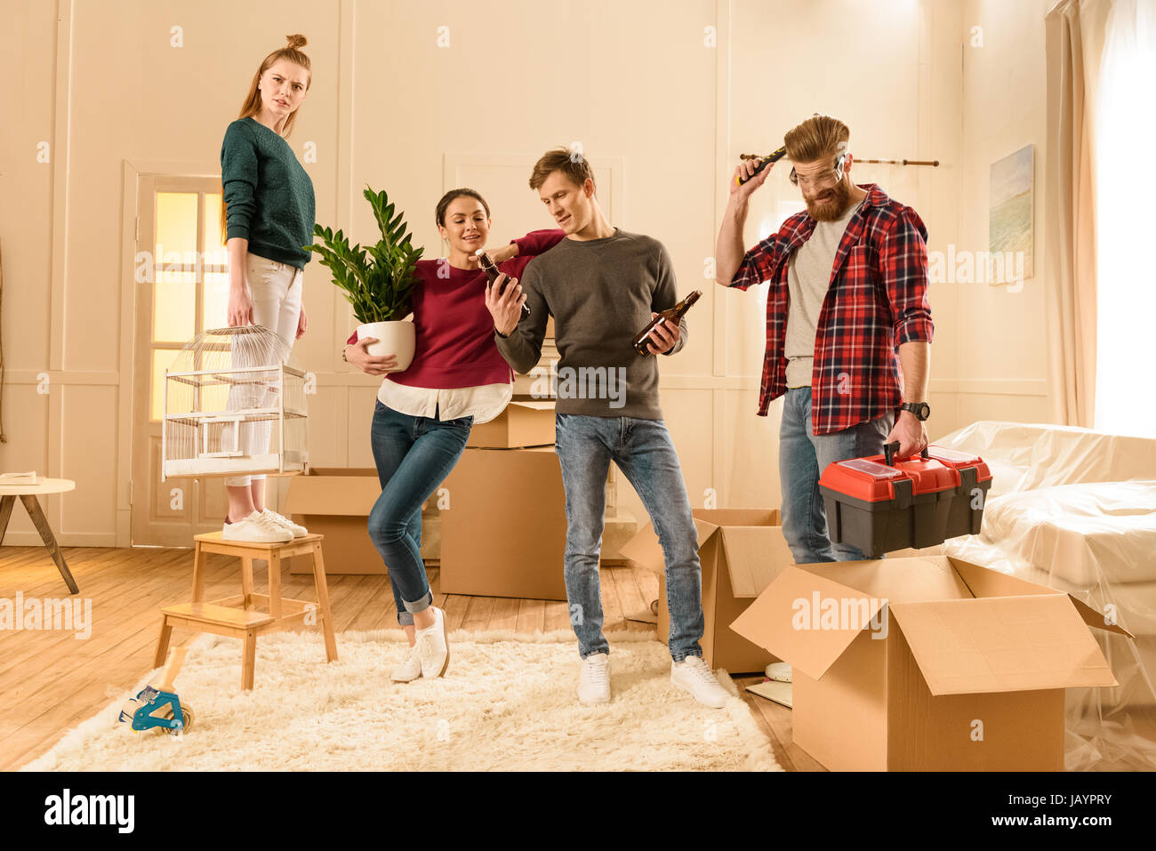 friends holding different things for moving into new house Stock Photo ...