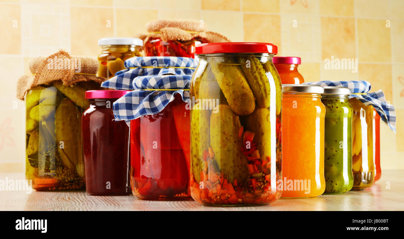 Composition with jars of marinated food. Pickled vegetables and jams ...