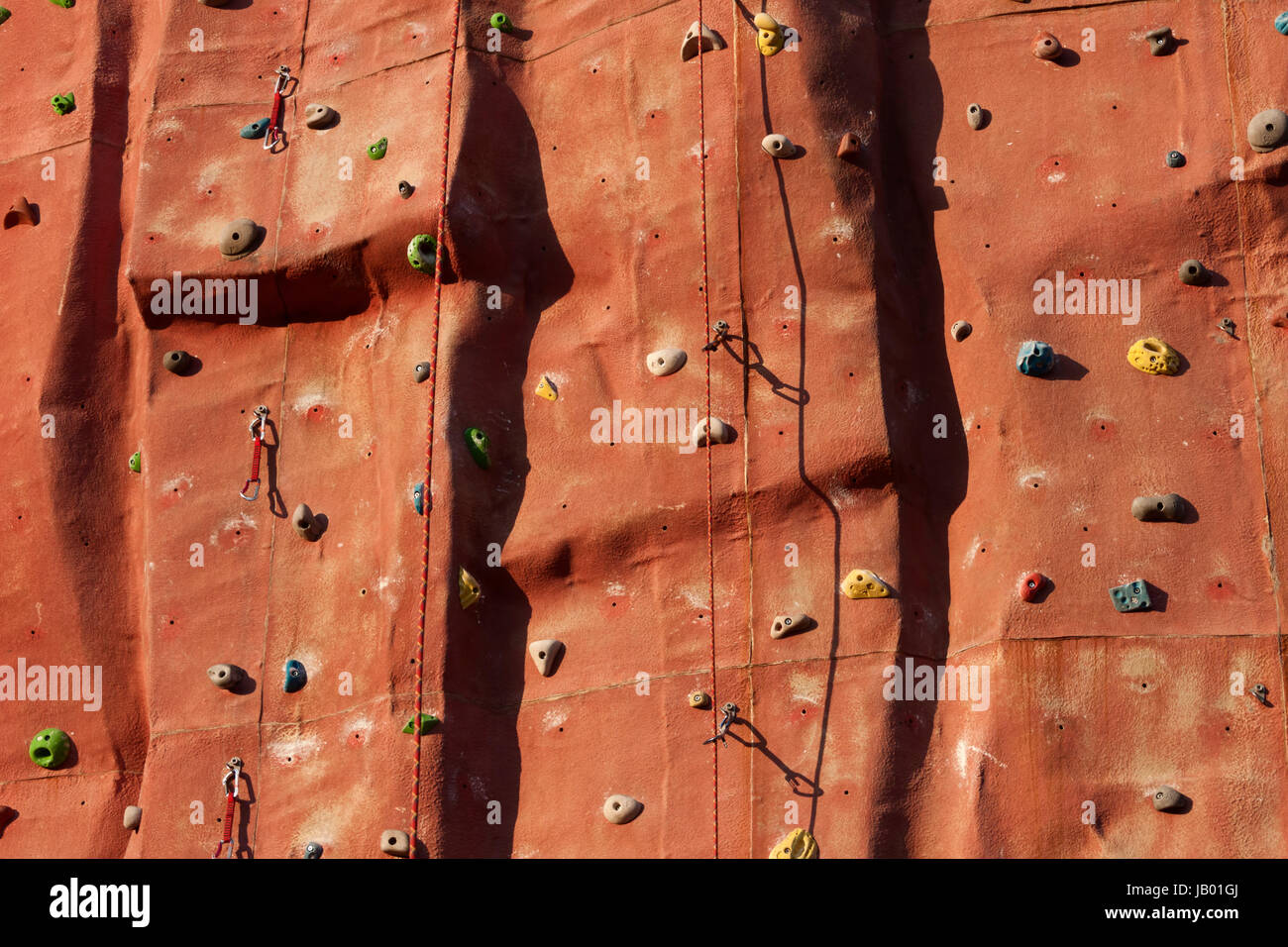 An artificial rock textured climbing wall background with holds, incuts ...