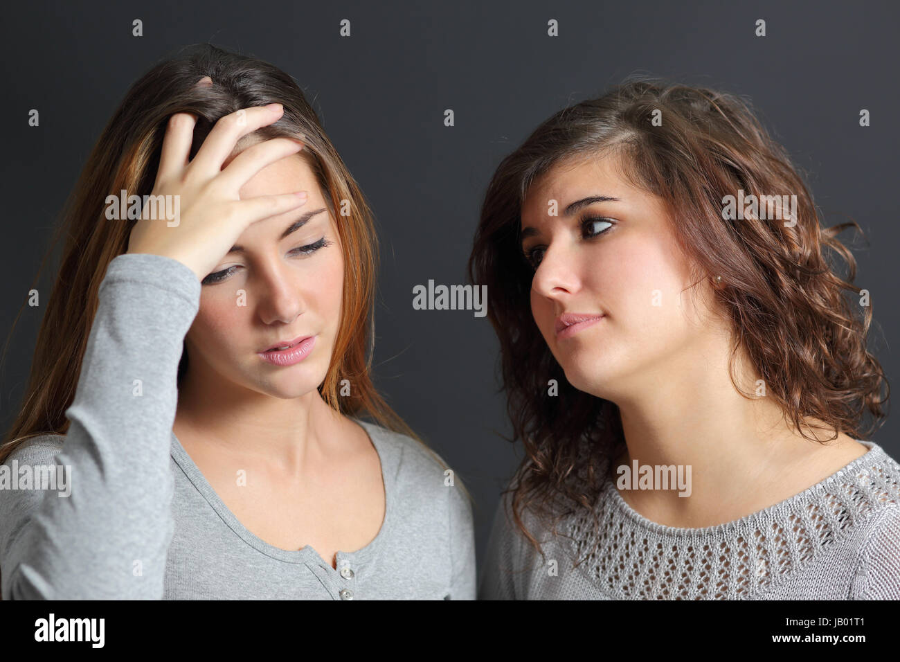 Woman worried and another one comforting her on a dark background Stock ...
