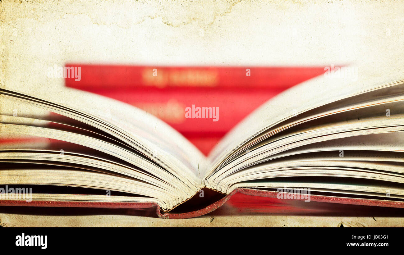 Vintage photo of open book with pile in the background Stock Photo - Alamy