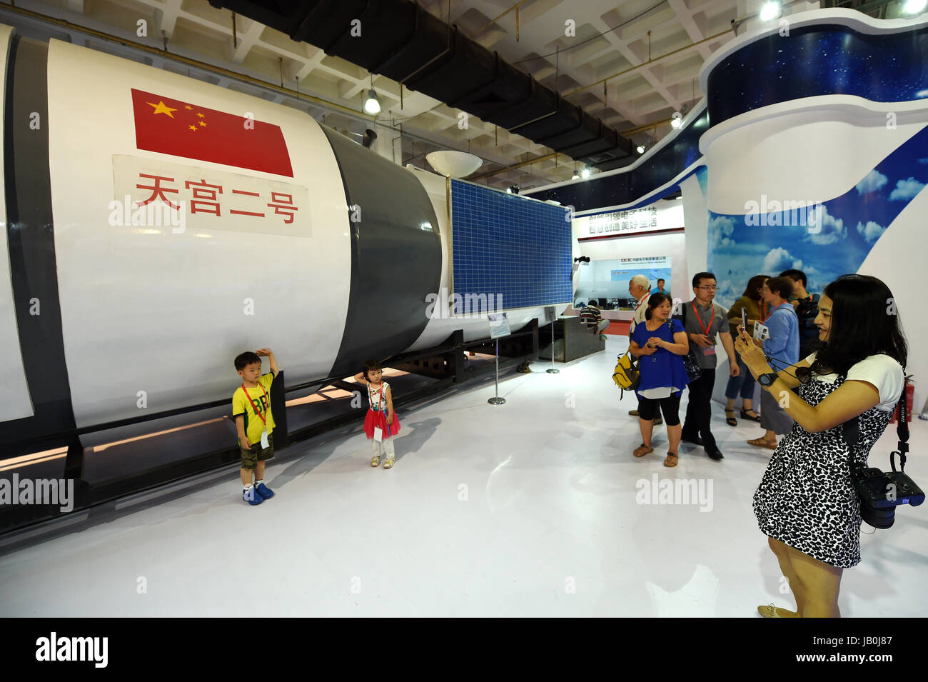 Beijing, China. 9th June, 2017. A visitor poses with a model of the ...