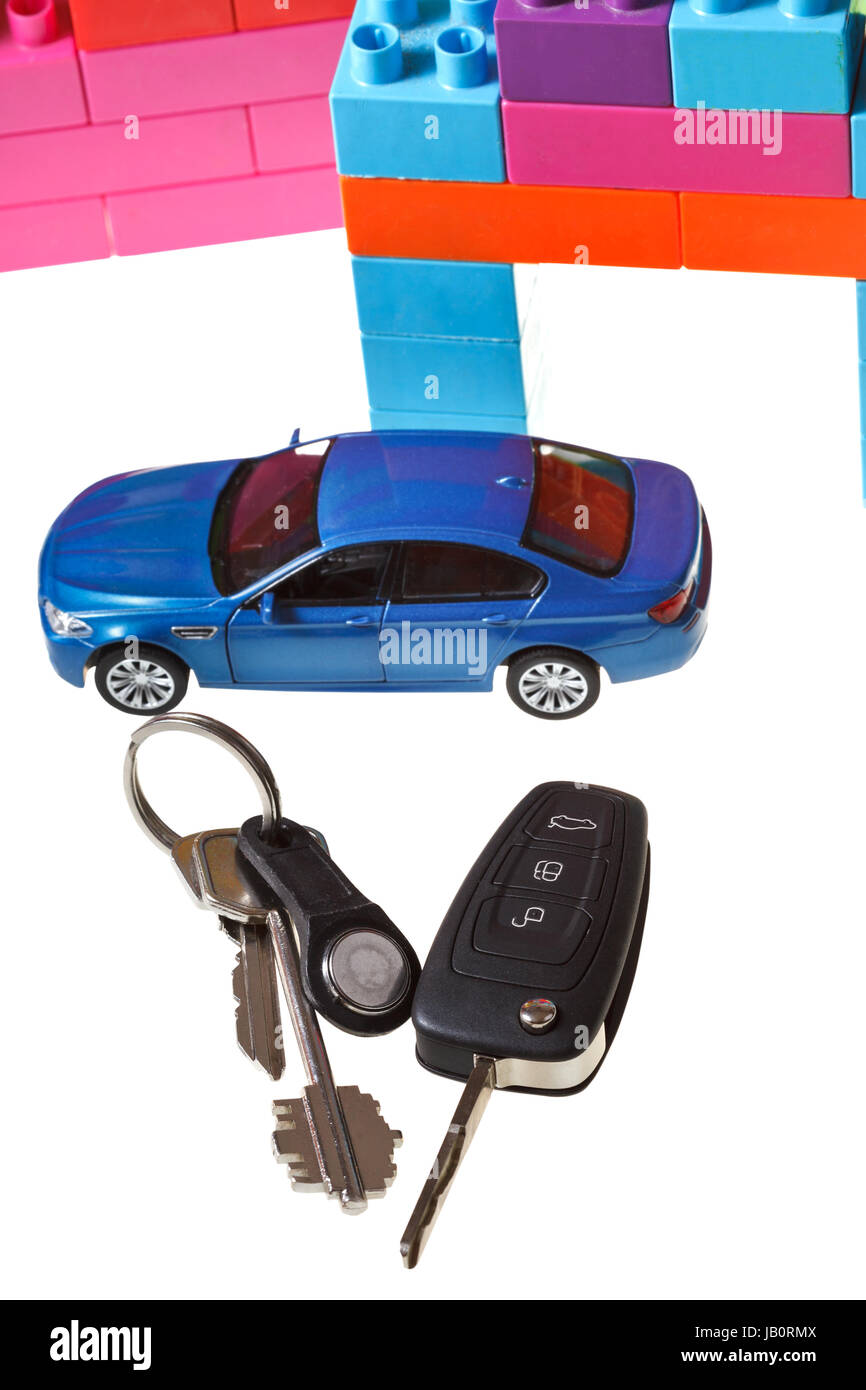top view of door key, vehicle keys, blue model car and plastic block ...
