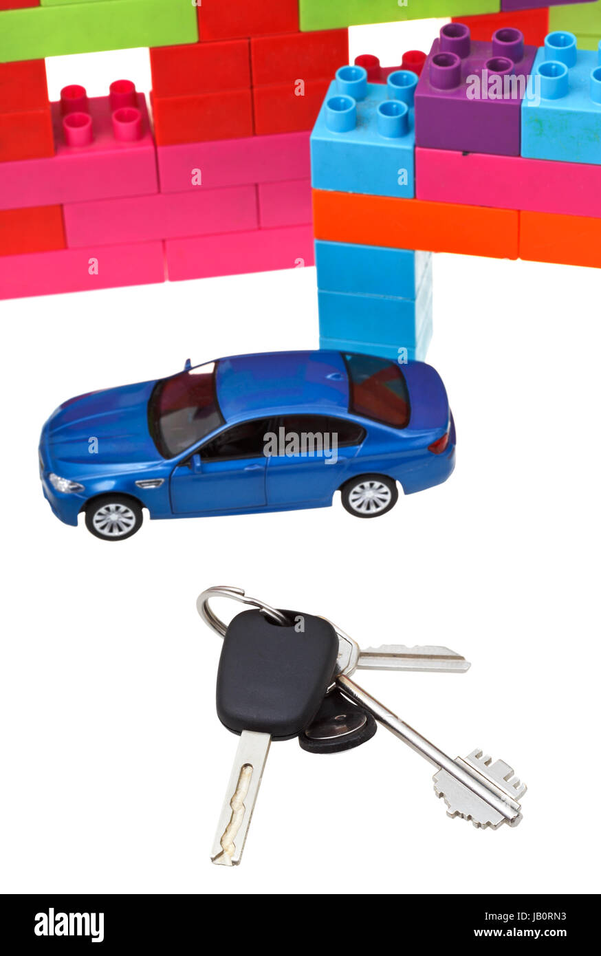 door and car keys close up, blue model car and plastic block house ...