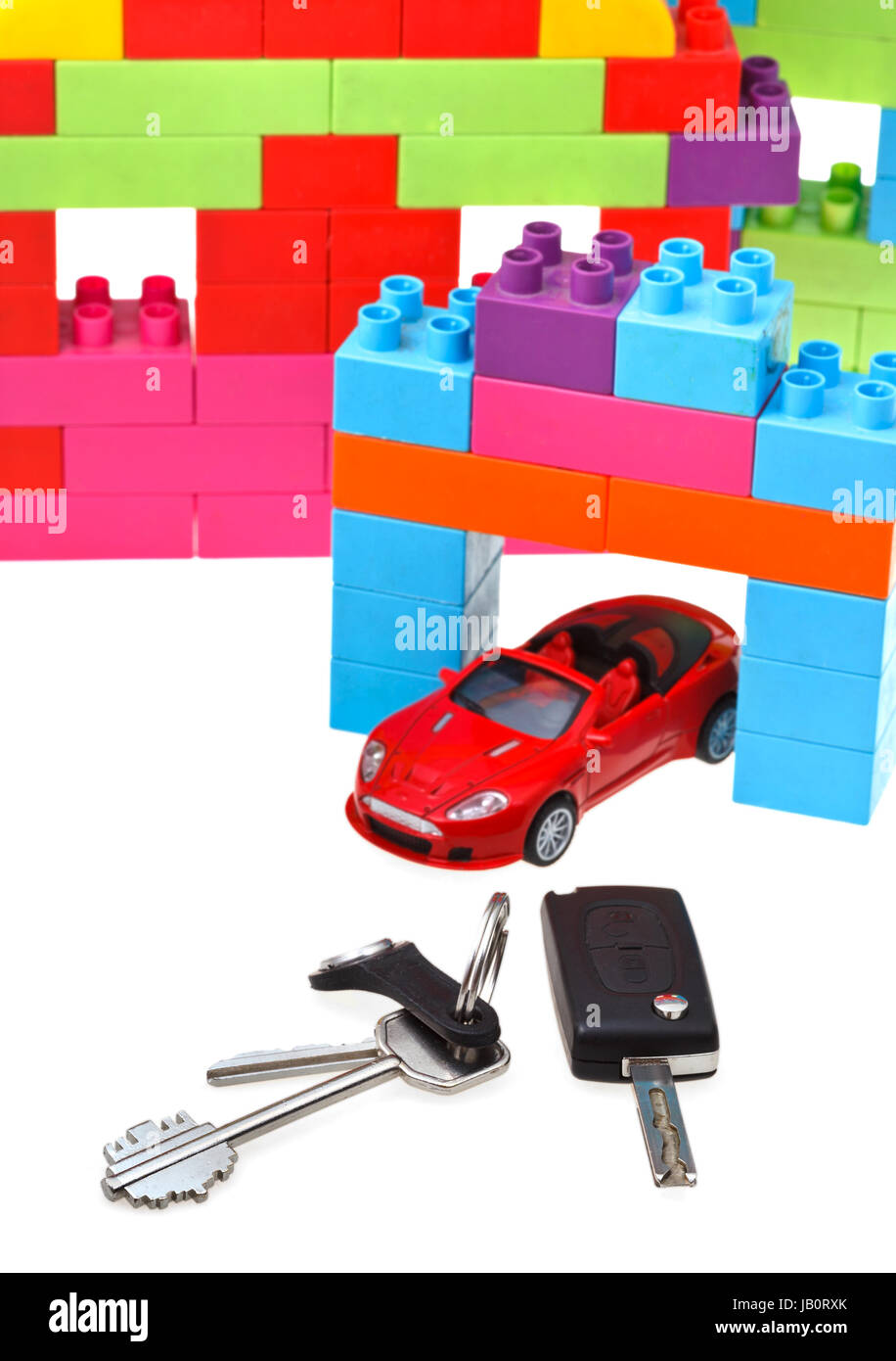 door key, vehicle keys close up, red model car and plastic block house ...