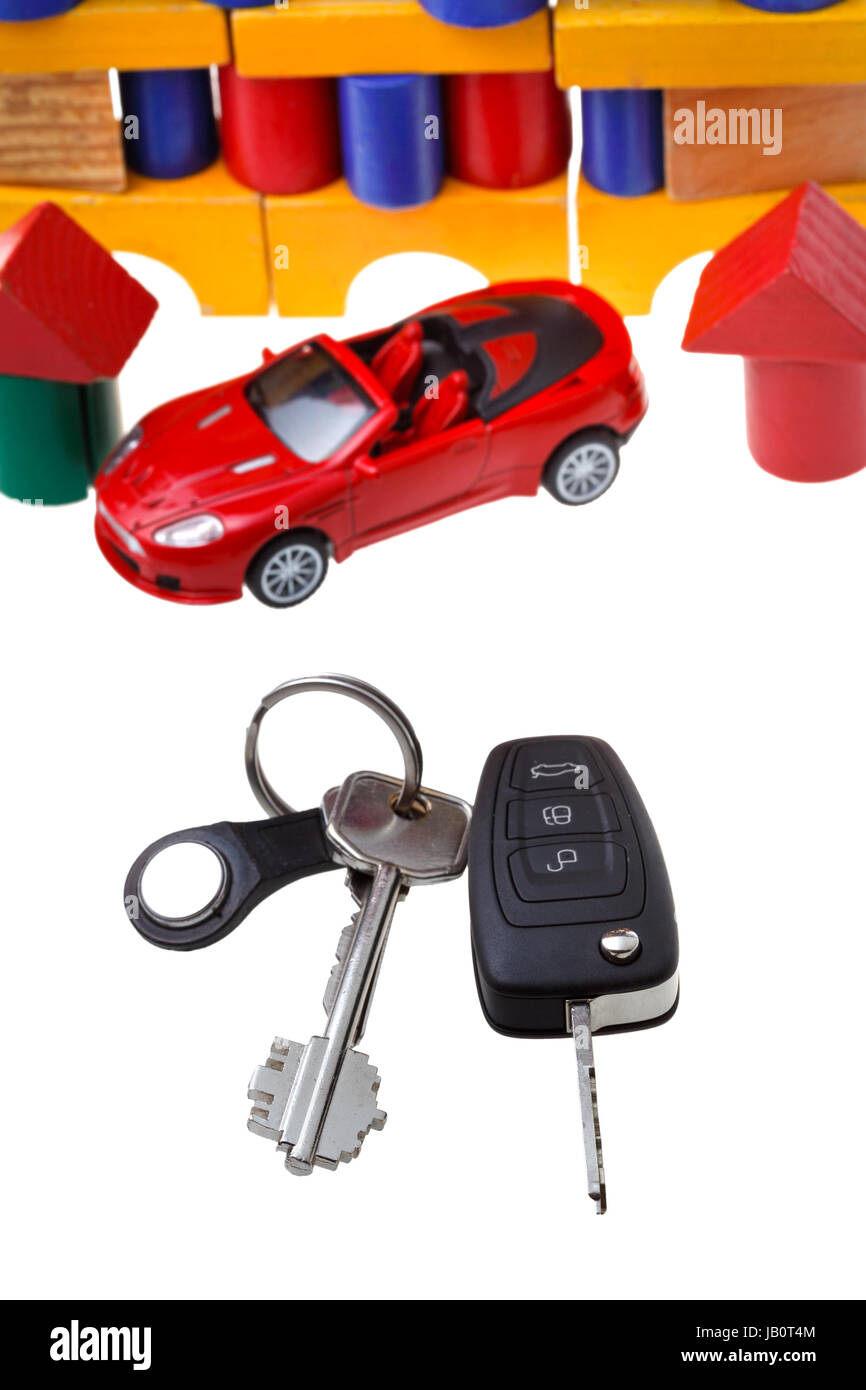 door keys, vehicle key, new red car model close up and wooden block toy ...