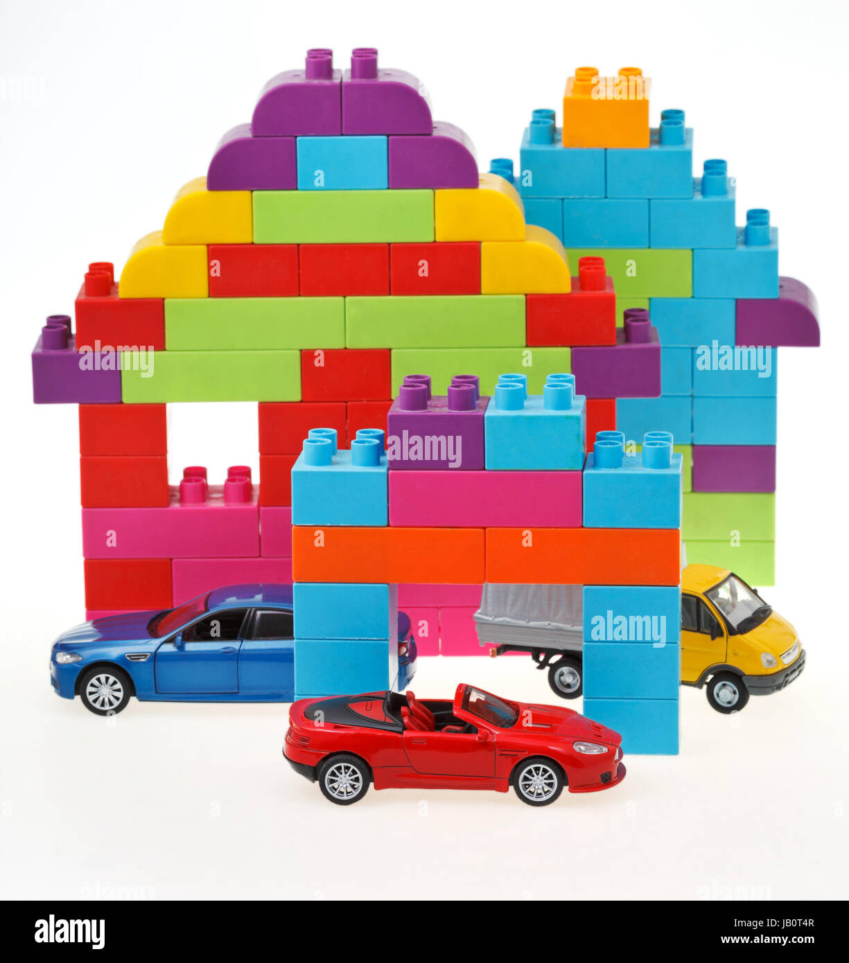 plastic block house and three model cars on white background Stock ...