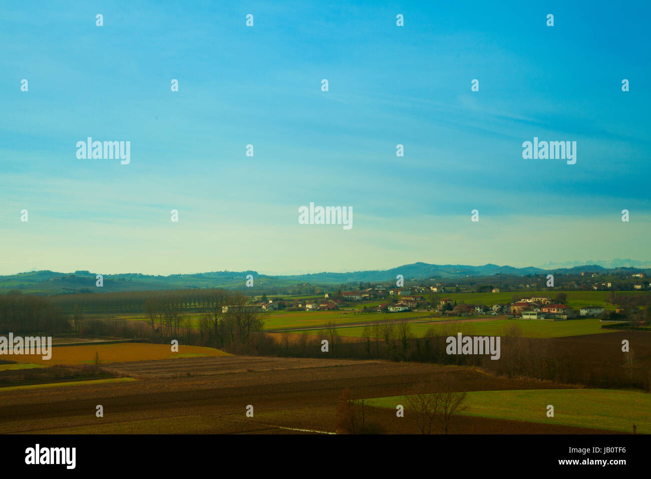 Landscape of fields under blue sky with far mountains Stock Photo - Alamy