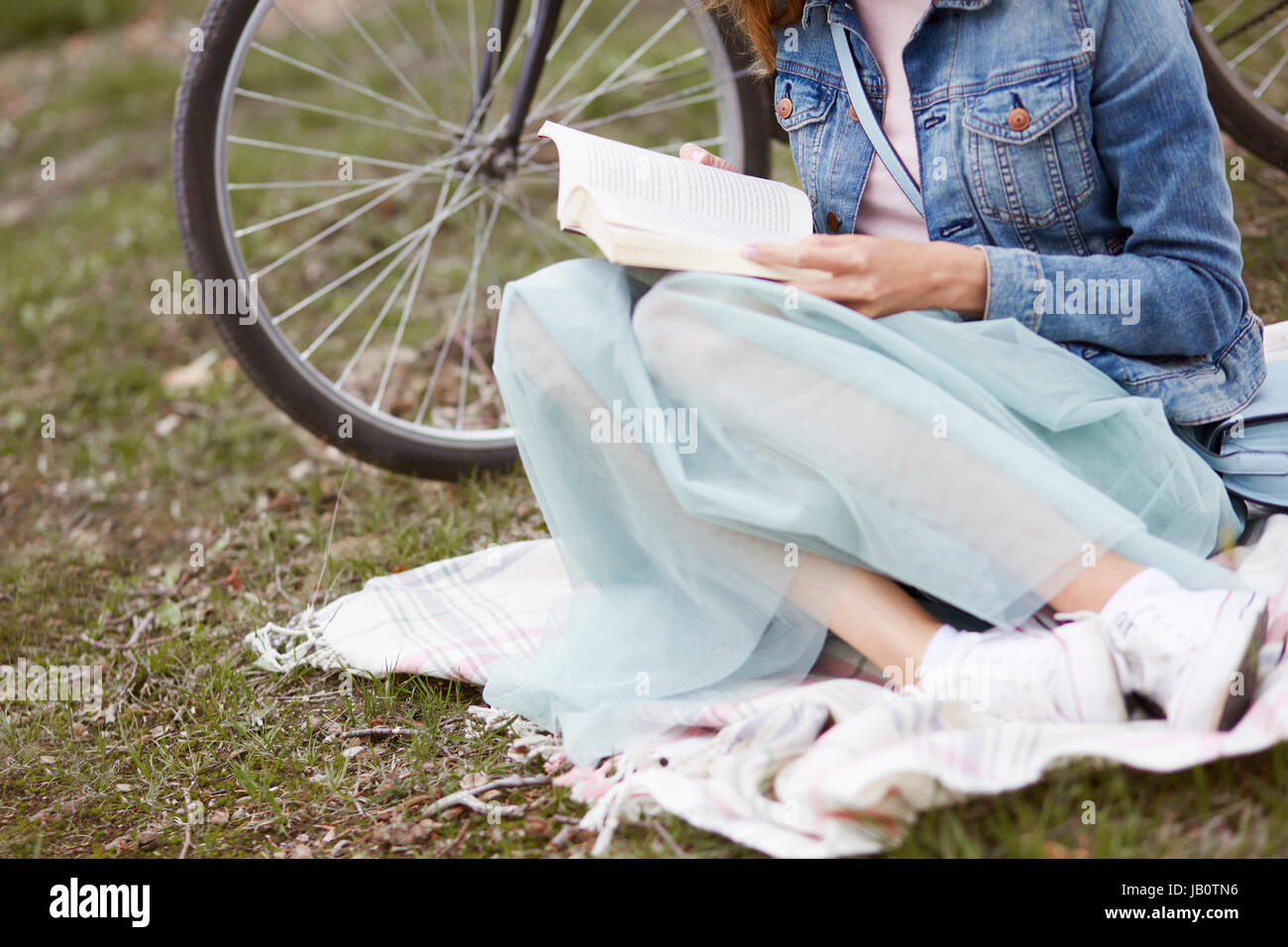 Low section of woman which reading a book outside Stock Photo - Alamy