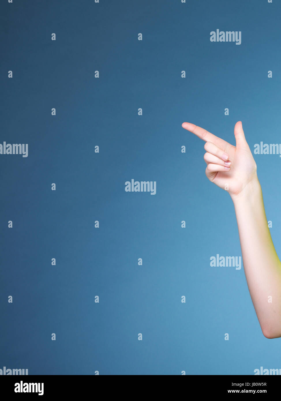 Woman hand pointing direction to follow with finger blue background ...