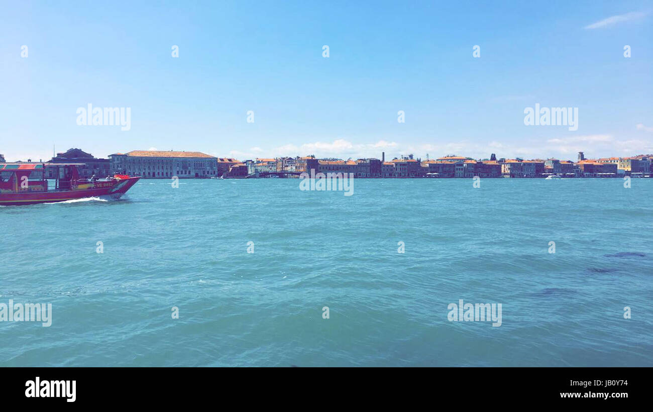 Boat travelling on the Grand Canal against backdrop of the opposite ...