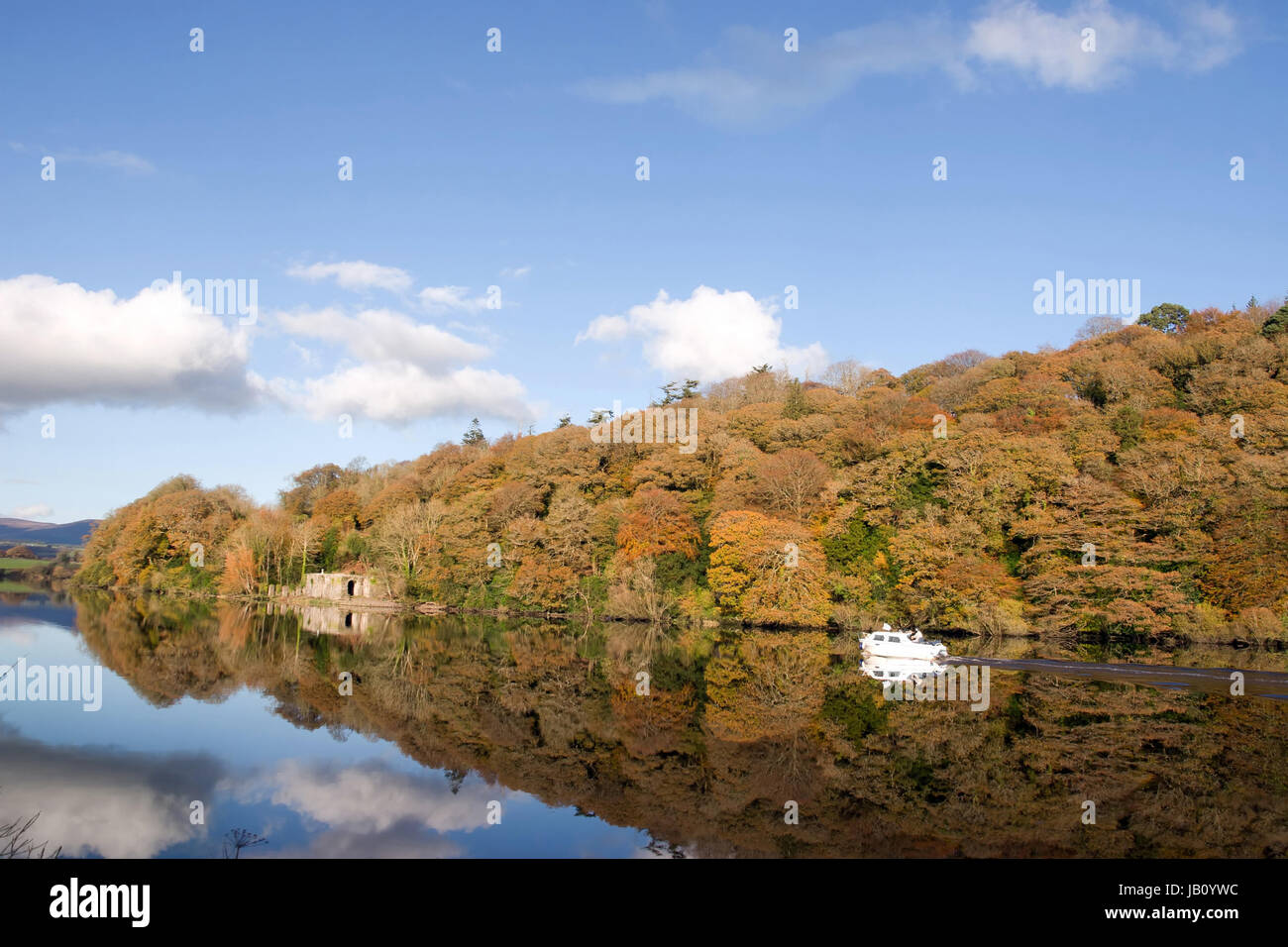 boat cruising down the calm river blackwater in county Waterford ...