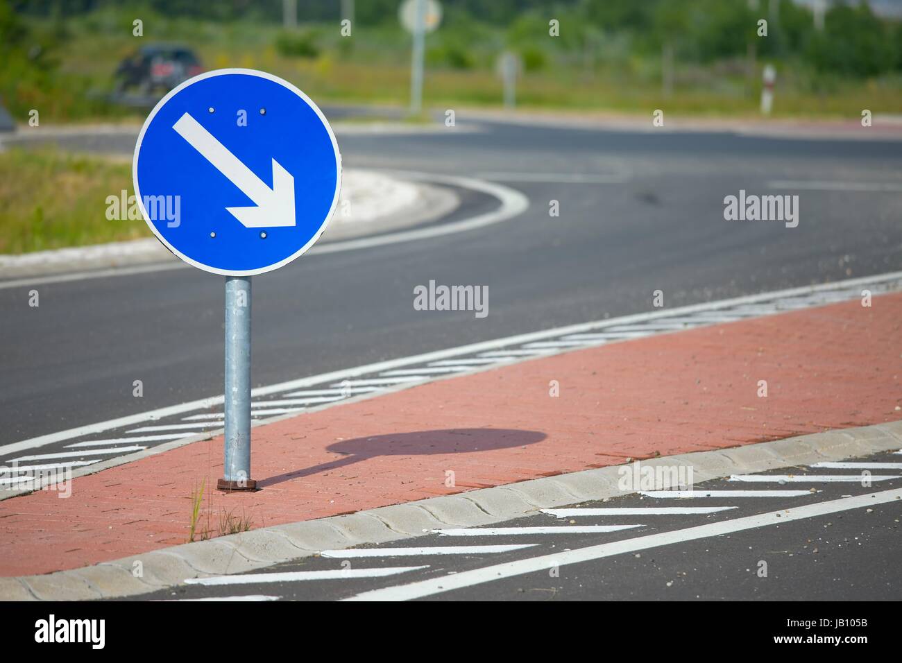 Arrow sign at a roundabout Stock Photo - Alamy