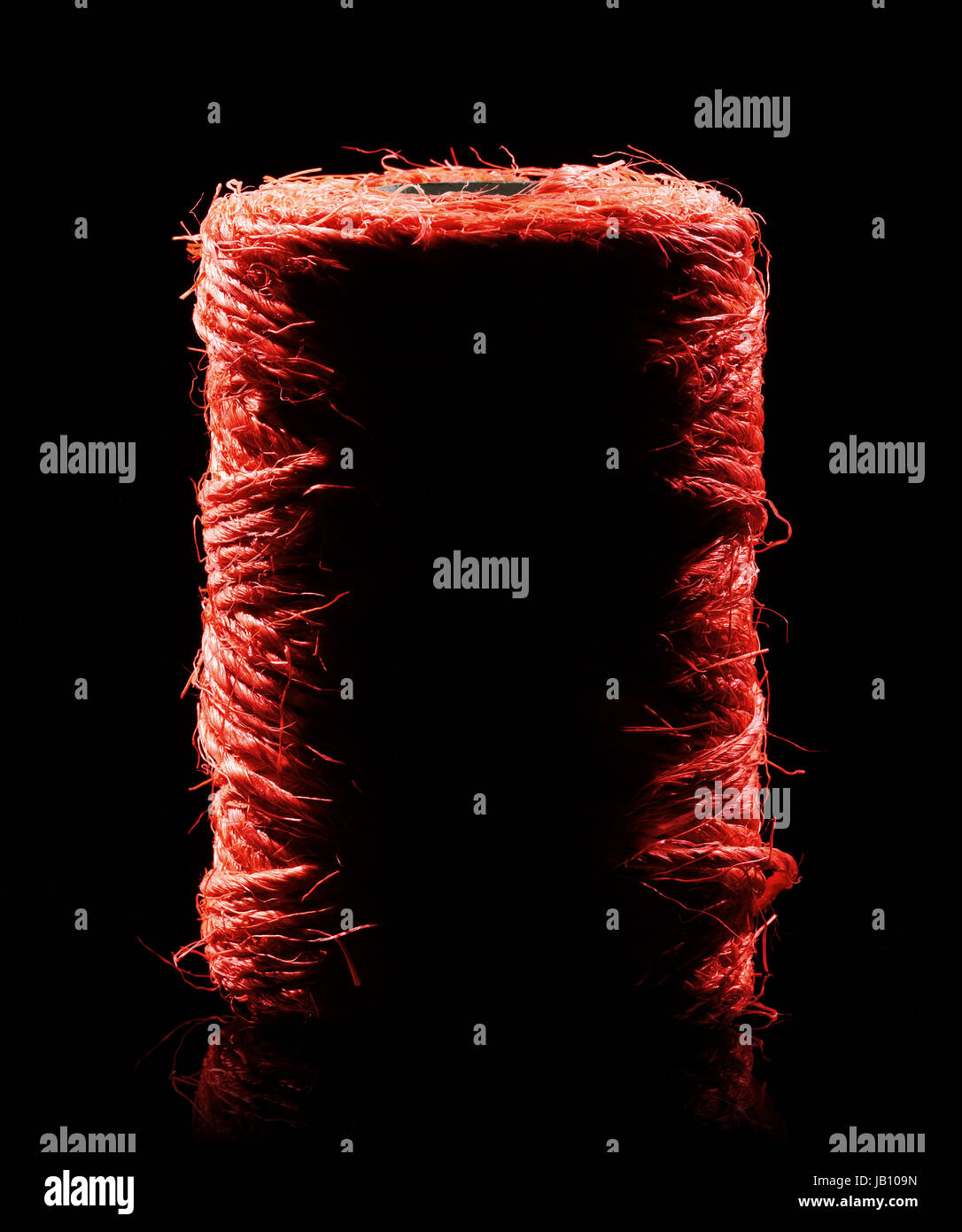 coil of red yarn in dark reflective back Stock Photo - Alamy