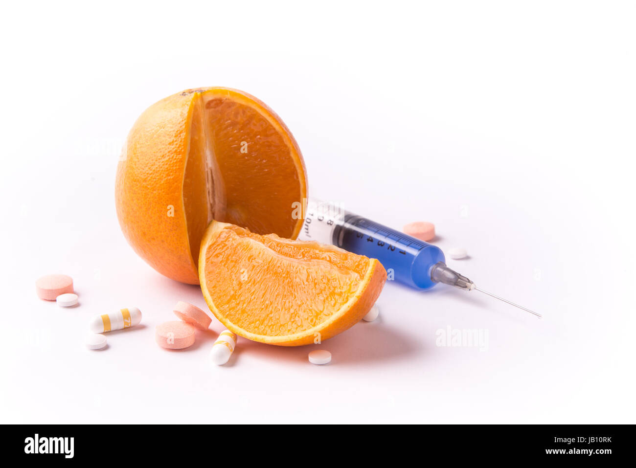 OGM orange fruit with pills and syringe Stock Photo - Alamy