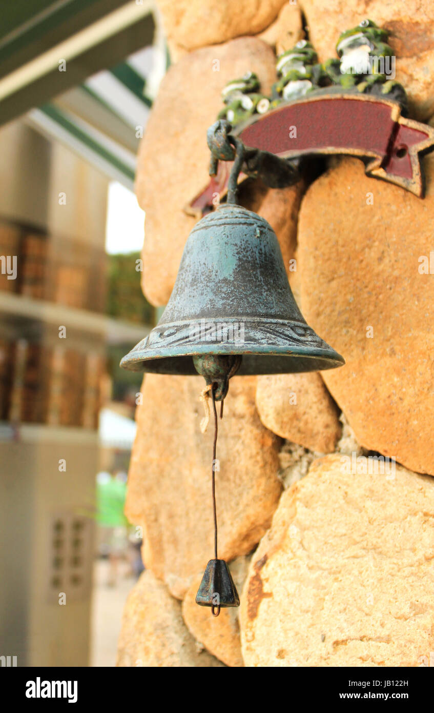 Antique bell hanging on stone wall Stock Photo - Alamy