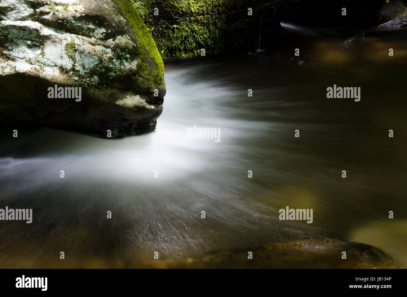 Water Gushing From Under Rock Stock Photo - Alamy