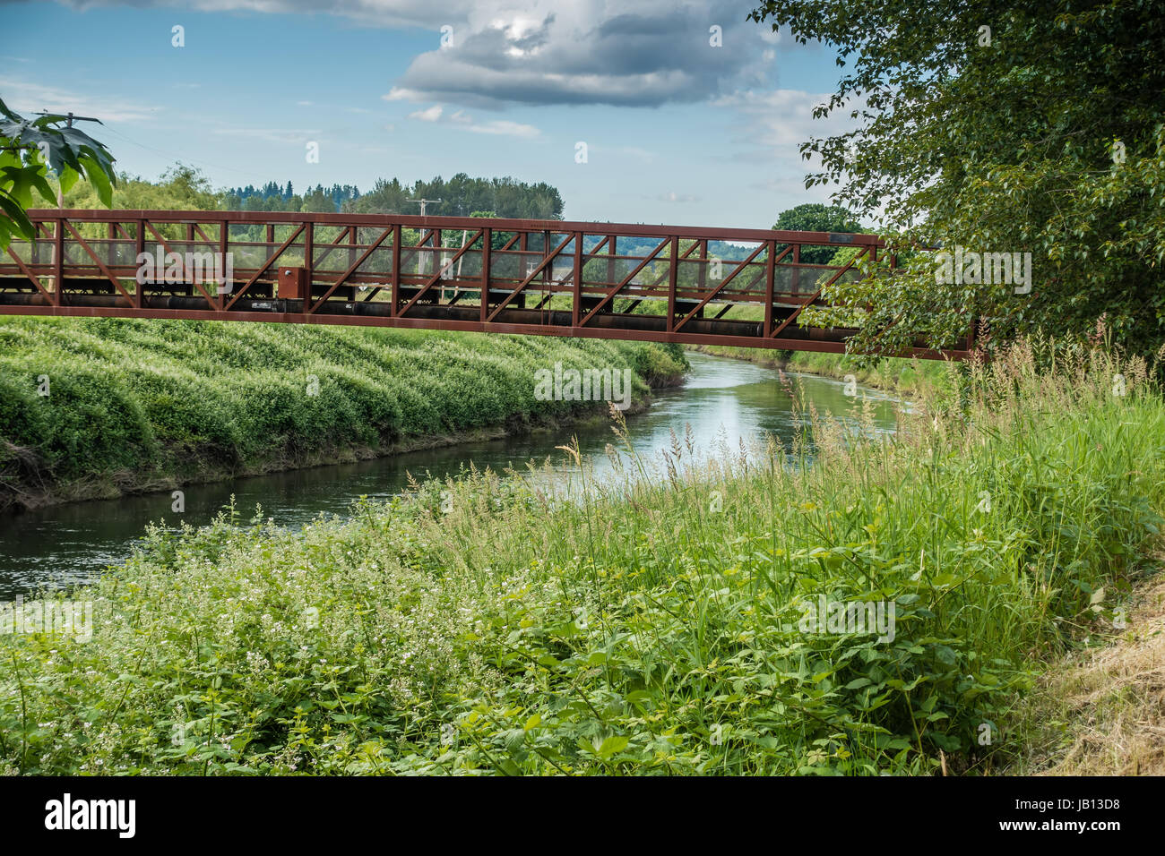 A rusted metal bridge spans the Green River in Kent, Washington Stock ...