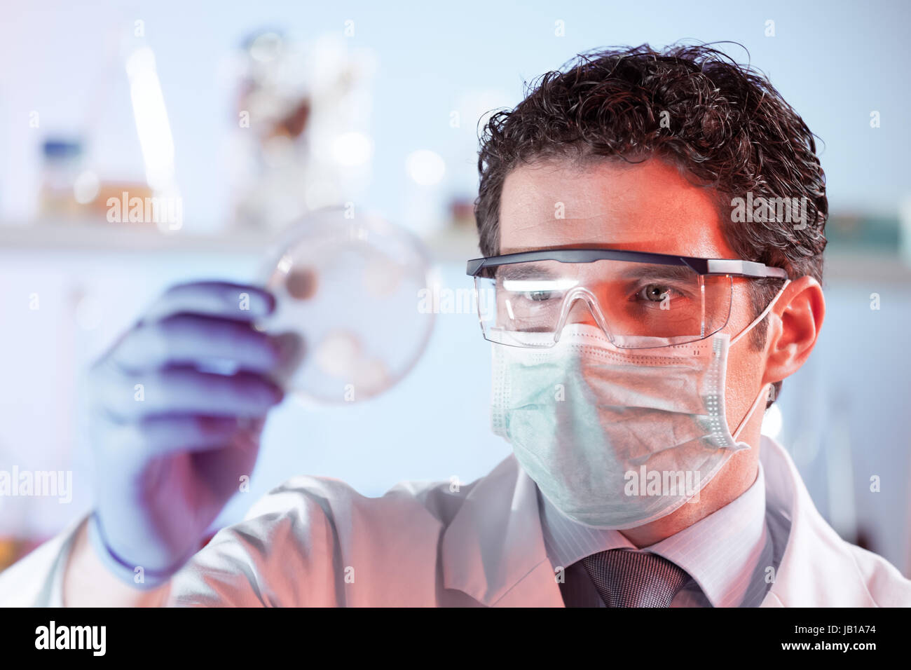 Mask and goggles protected life science researcher observing ...