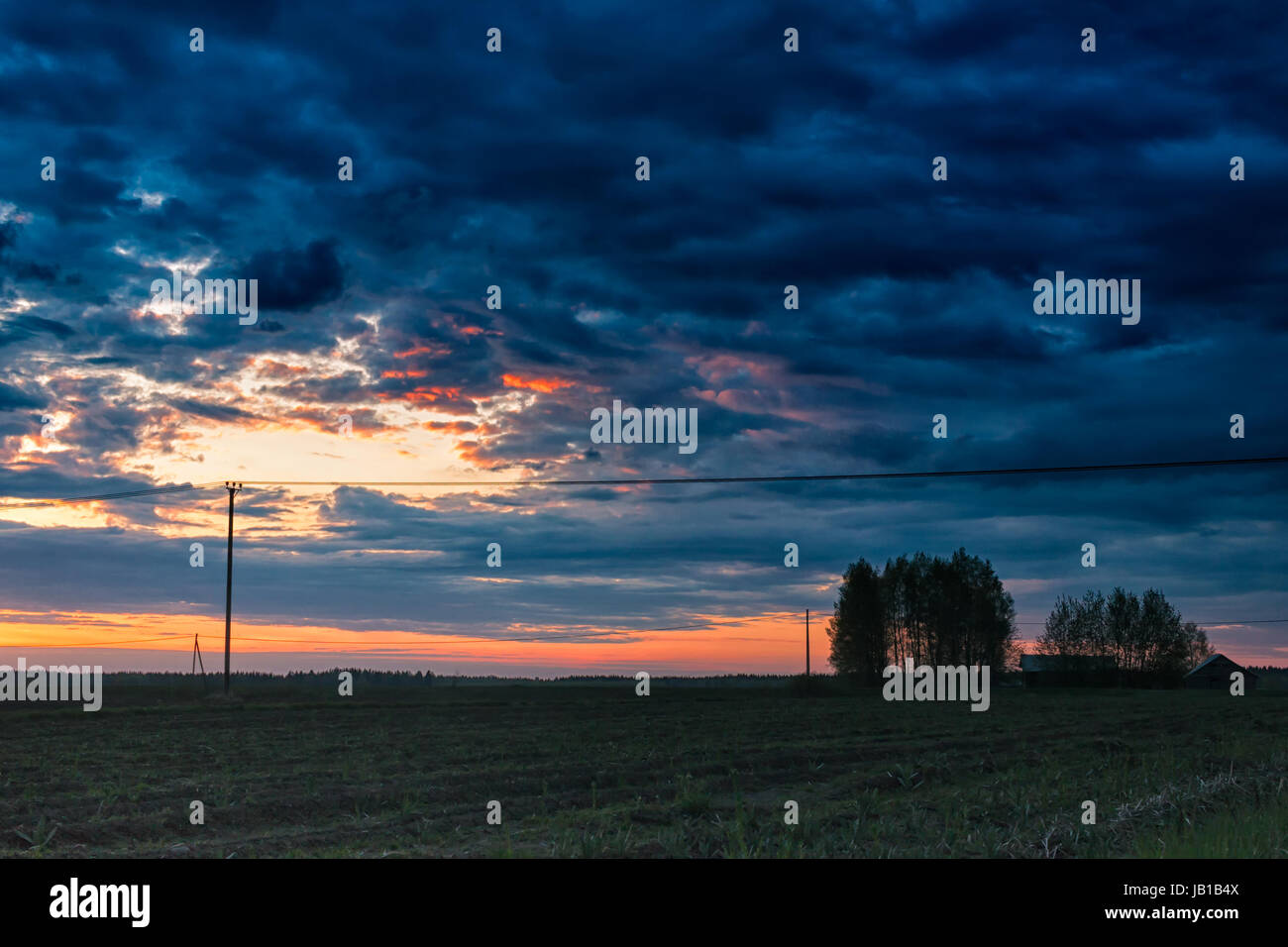 A beautiful sunset over the early summer fields of the Northern Finland ...