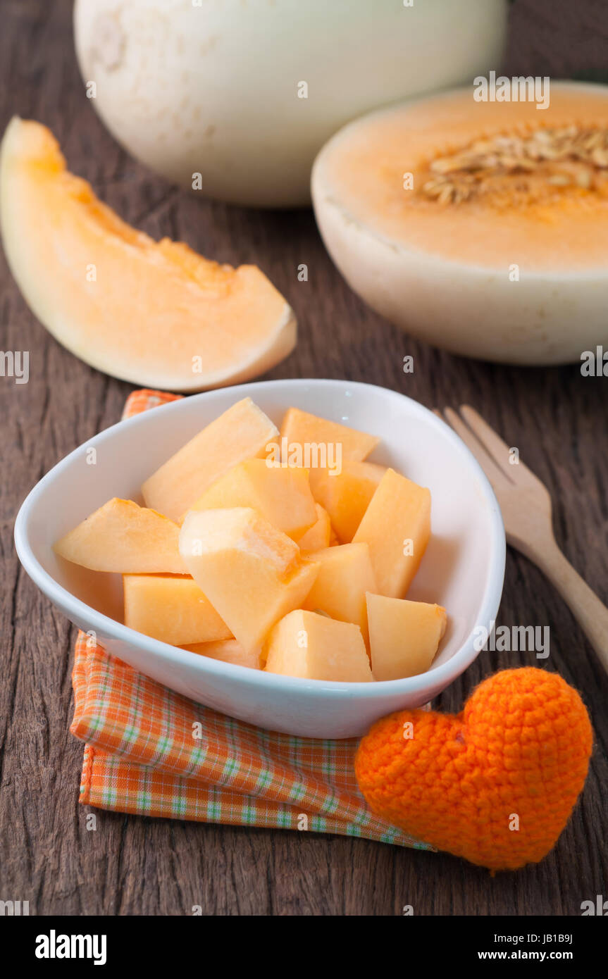 kitchen table with slice fresh cantaloupe melon on white plate and ...