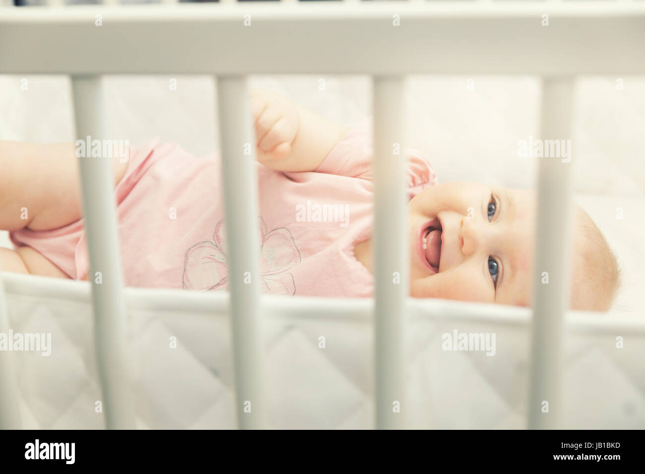 cheerful baby girl lying in crib at home Stock Photo - Alamy