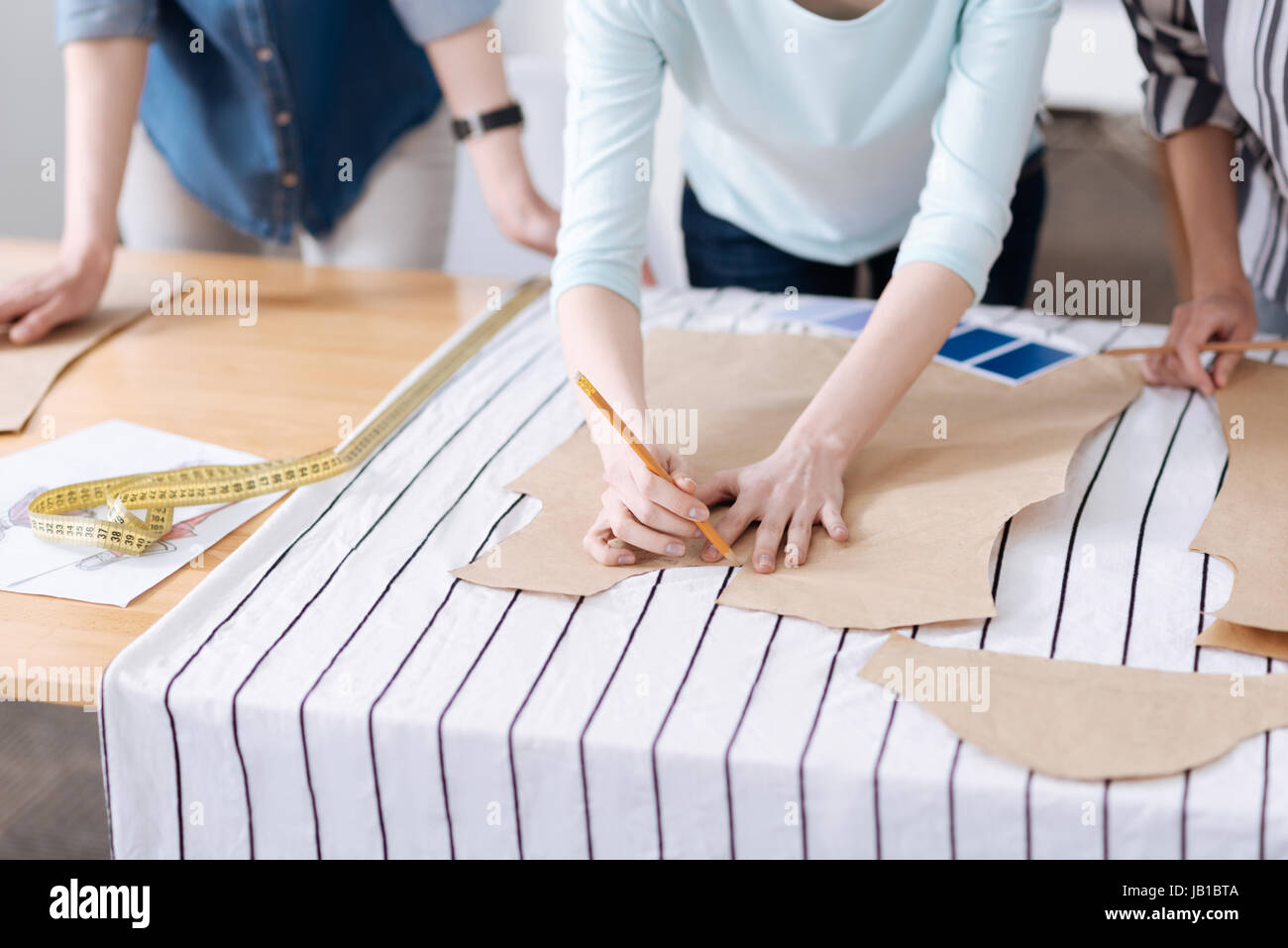 Delicate female hands tracing patterns on fabric Stock Photo - Alamy