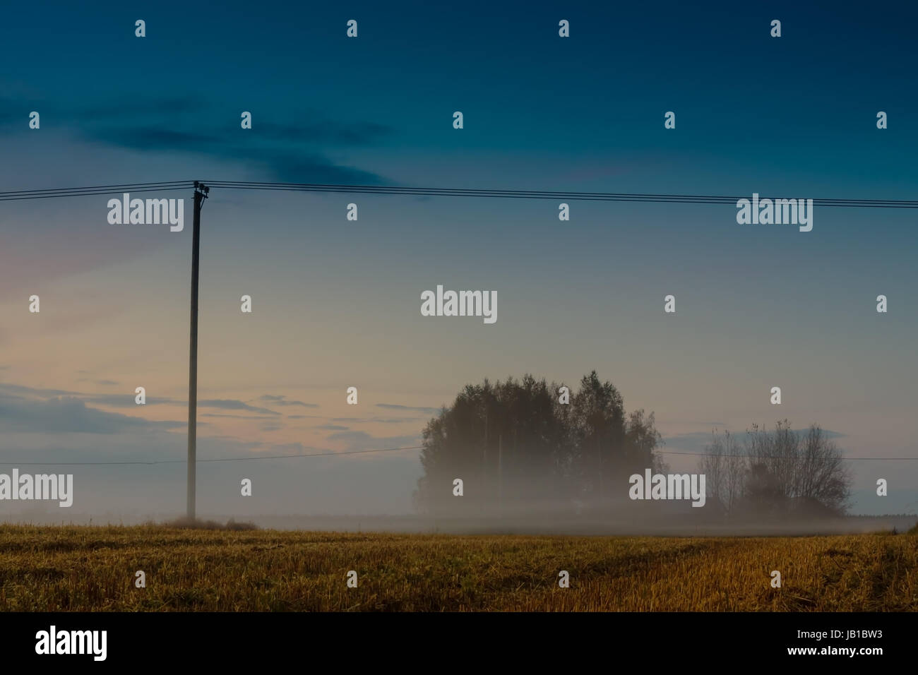 The mist rises from the fields on an autumn evening in the rural ...