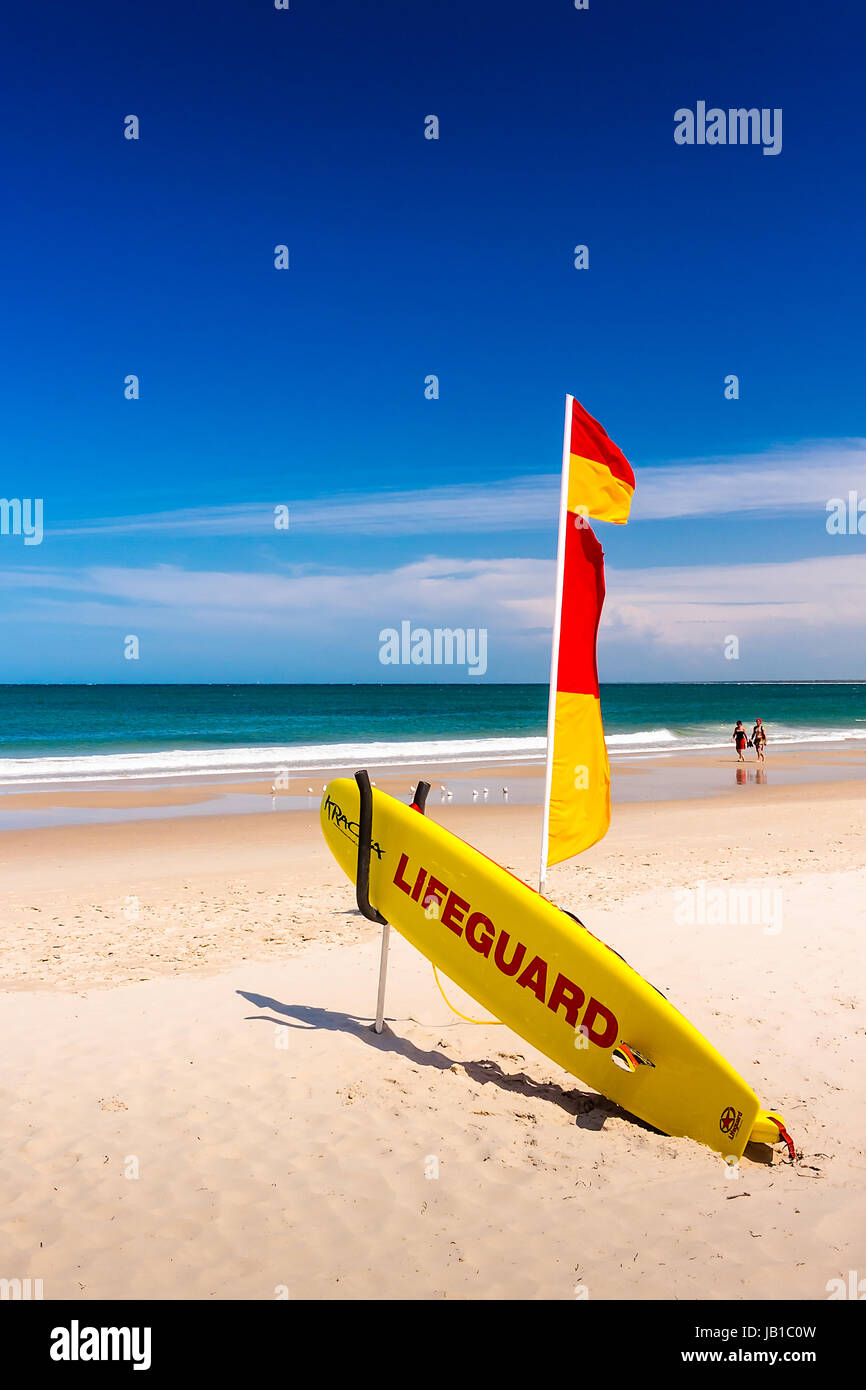 Lifeguard surfboard by the warning flag on the King's Beach at ...