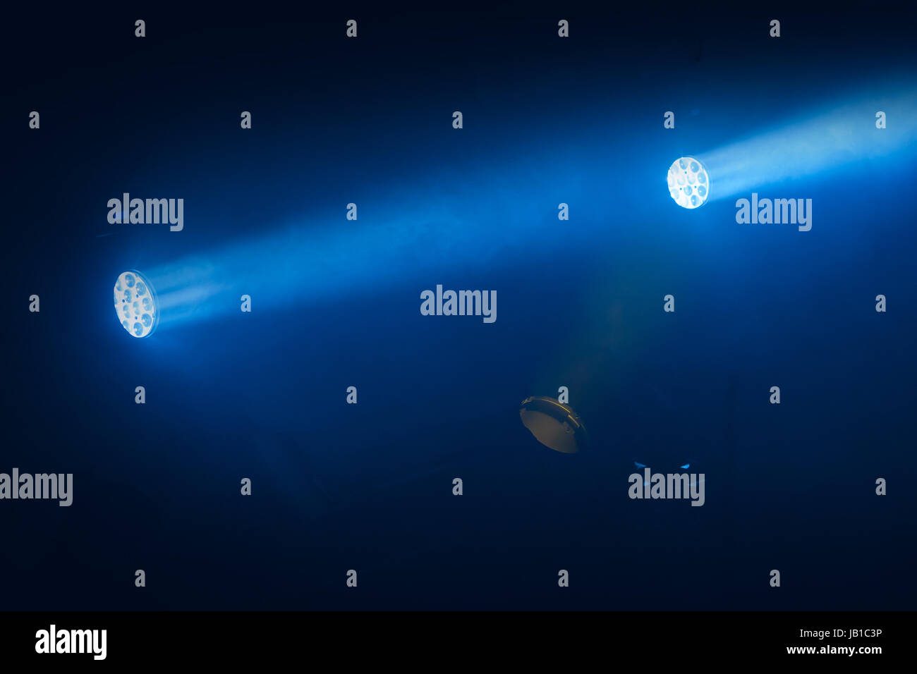Blue spot lights with rays in smoky dark, stage illumination equipment ...