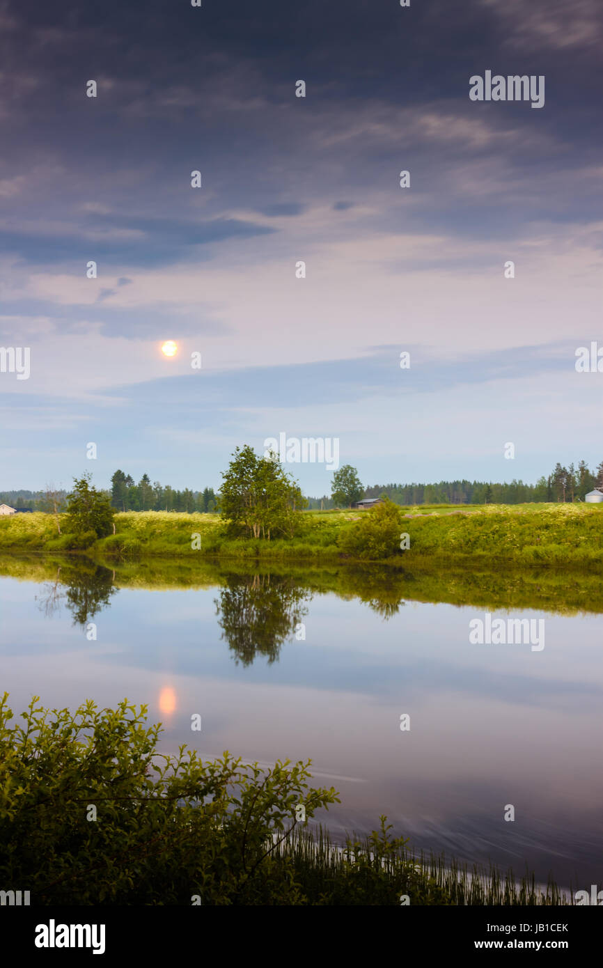 The river reflects the light of the full moon on a summer night in the ...