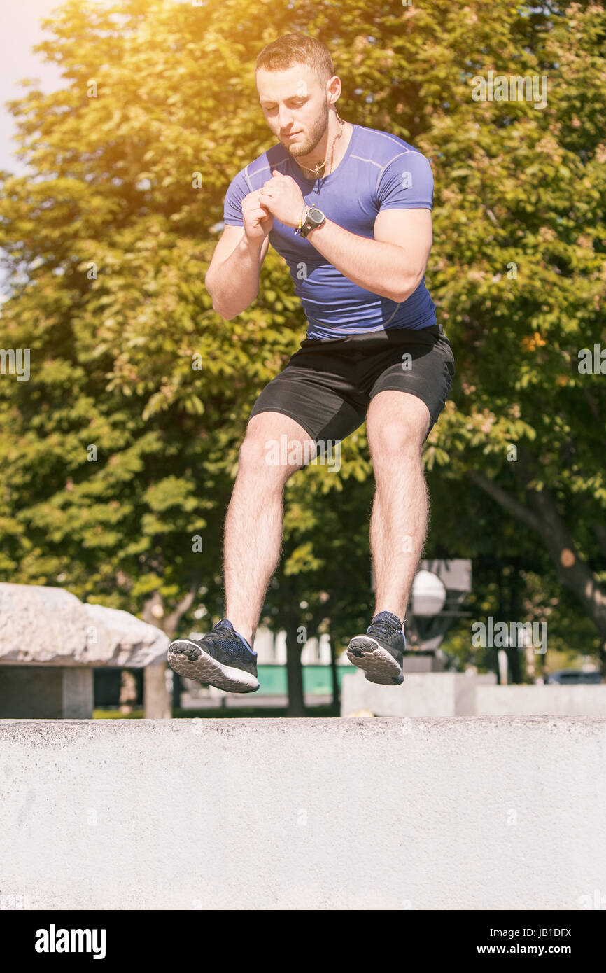 Fit man doing exercises outdoors at park Stock Photo - Alamy