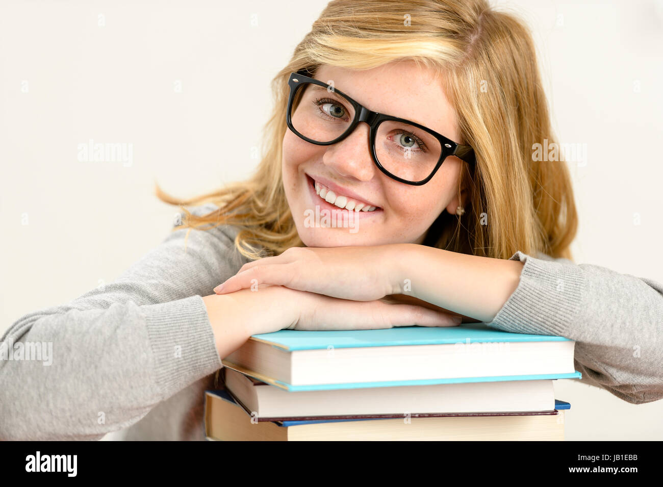 Happy girl student with stack of books smiling on white Stock Photo - Alamy