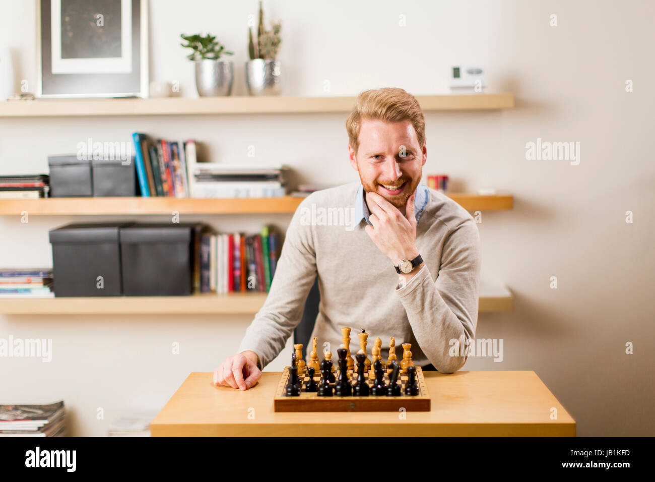 Portrait of a happy man playing chess at homme Stock Photo - Alamy